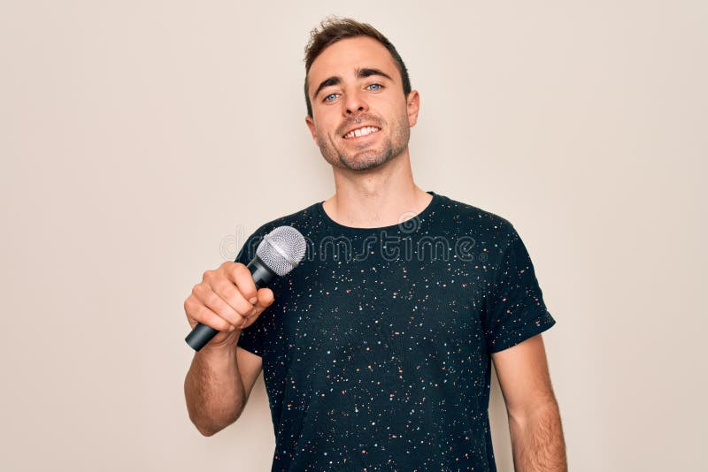 Young Handsome Singer Man with Blue Eyes Singing Using Microphone Over ...