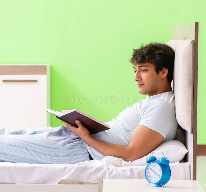 Young Handsome Student Reading Book in the Bed Stock Image - Image of ...