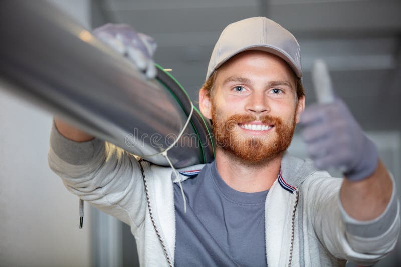 Young Happy Construction Worker on Site Holding Pipe Stock Image ...