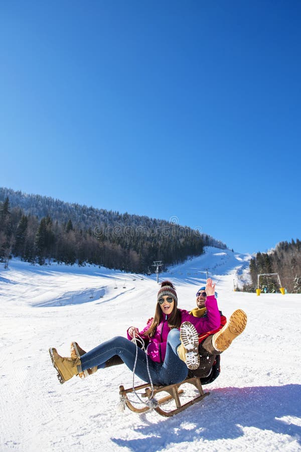 Young Happy Couple Sledding in Winter at Ski Center Stock Photo - Image ...