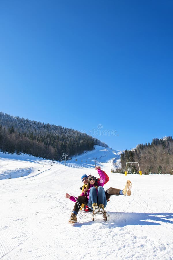 Young Happy Couple Sledding in Winter at Ski Center Stock Image - Image ...