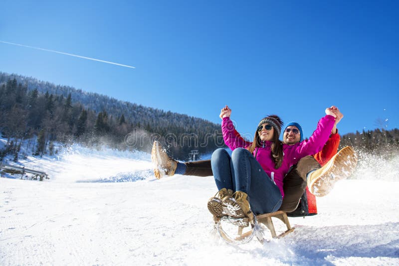 Young Happy Couple Sledding in Winter at Ski Center Stock Photo - Image ...