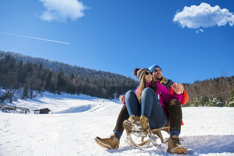 Young Happy Couple Sledding in Winter at Ski Center Stock Photo - Image ...