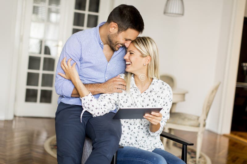 Young Happy Couple Surfing on the Web on Tablet at Home Stock Image ...
