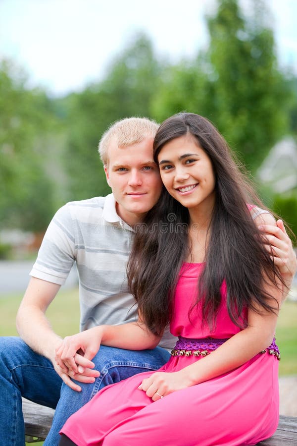 Young Happy Diverse Couple Sitting Together Outdoors Stock Image ...