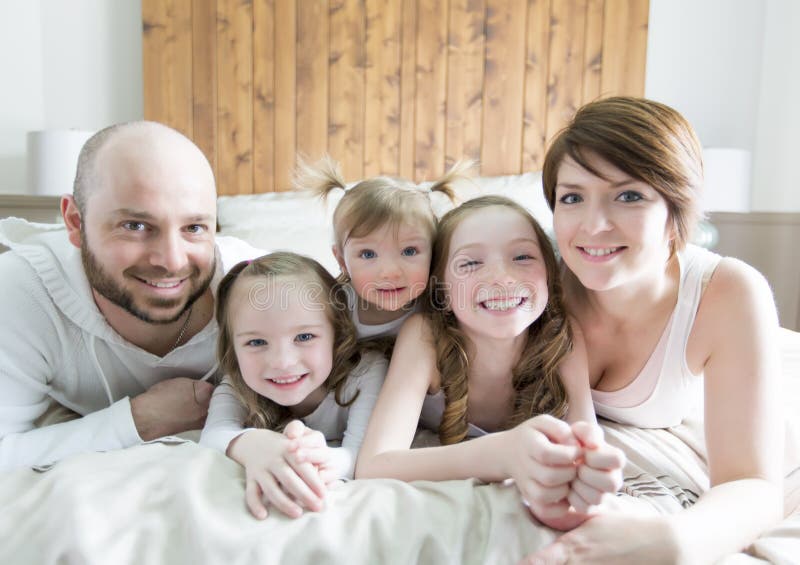 Young Happy Family of Five on Bedroom Stock Photo - Image of parent ...