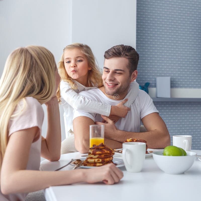 Young Happy Family Having Breakfast and Having Fun Stock Photo - Image ...