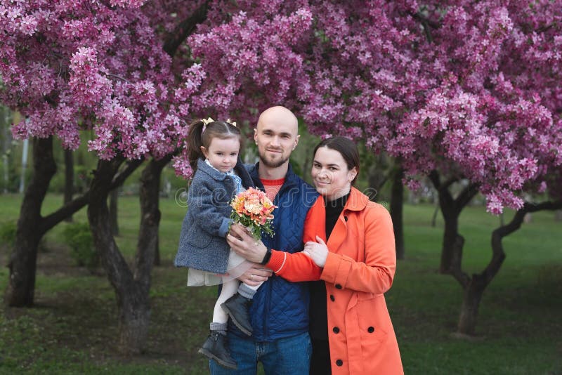 Young Happy Family in the Park in Spring on the Background of a ...