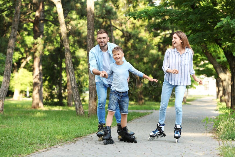Young Happy Family Roller Skating in Park Stock Photo - Image of care ...