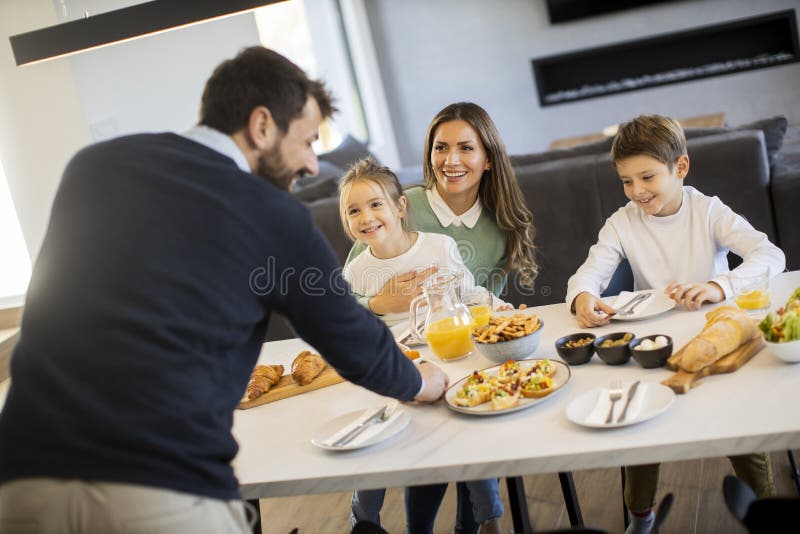 Young Happy Family Talking while Having Breakfast at Dining Table Stock ...