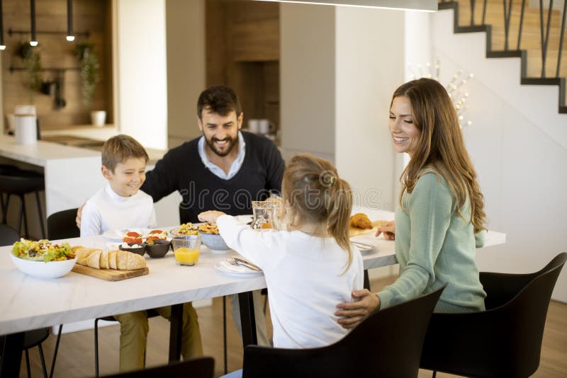 Young Happy Family Talking while Having Breakfast at Dining Table Stock ...