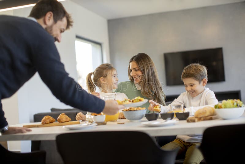 Young Happy Family Talking while Having Breakfast at Dining Table Stock ...