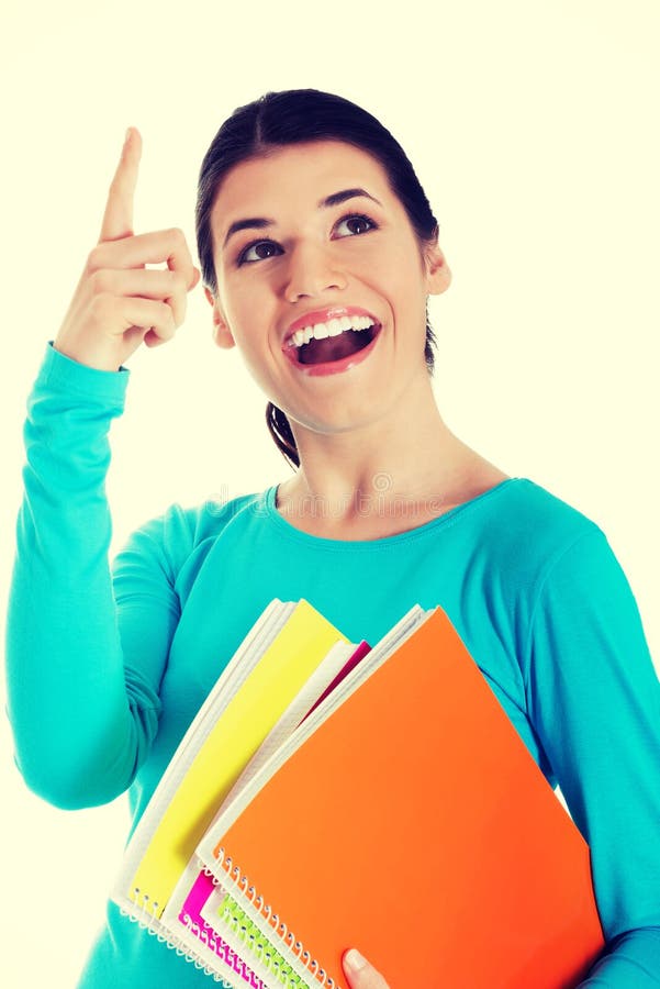 Young Happy Female Student Pointing Up Holding Workbooks Stock Photos ...