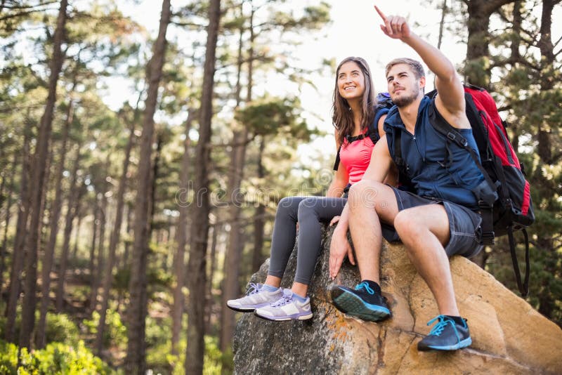 Young Happy Joggers Sitting on Rock Feeling and Pointing at Something ...