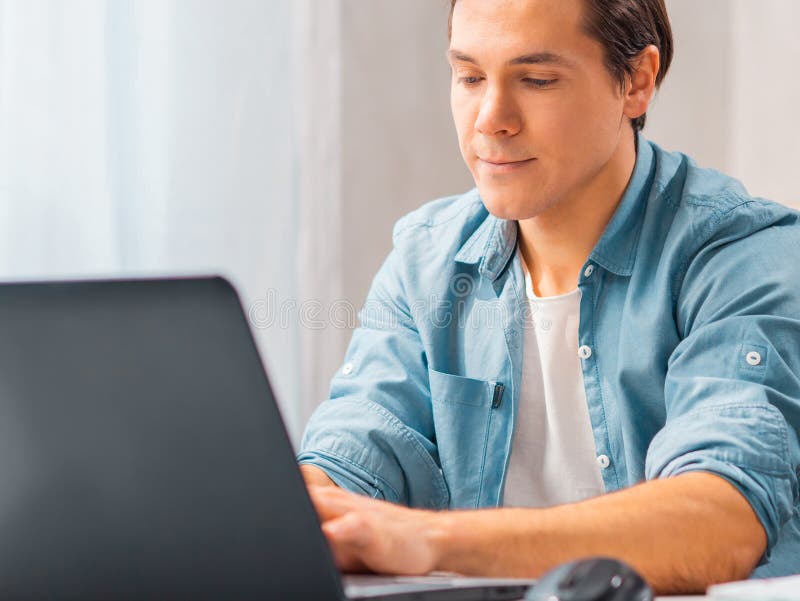 Young Man Works at a Laptop Computer. Freelancer, Remote Worker or ...