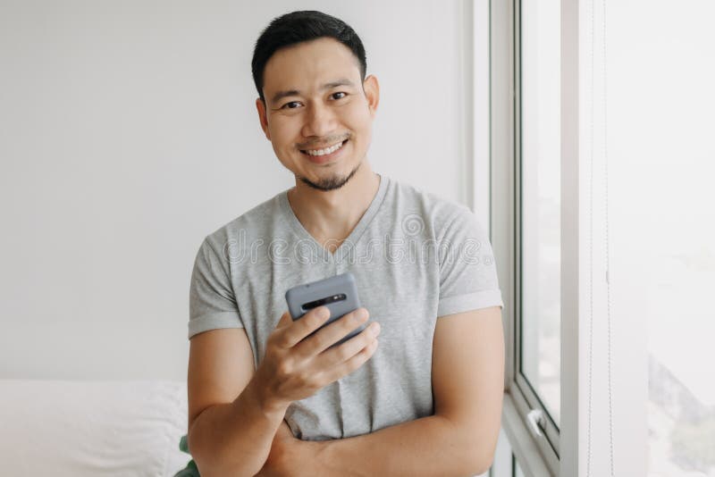 Young Happy Smiling Asian Man Using Smartphone Feels Relax and ...