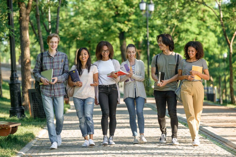 Young Happy Students Walking while Talking. Looking Aside. Stock Image ...