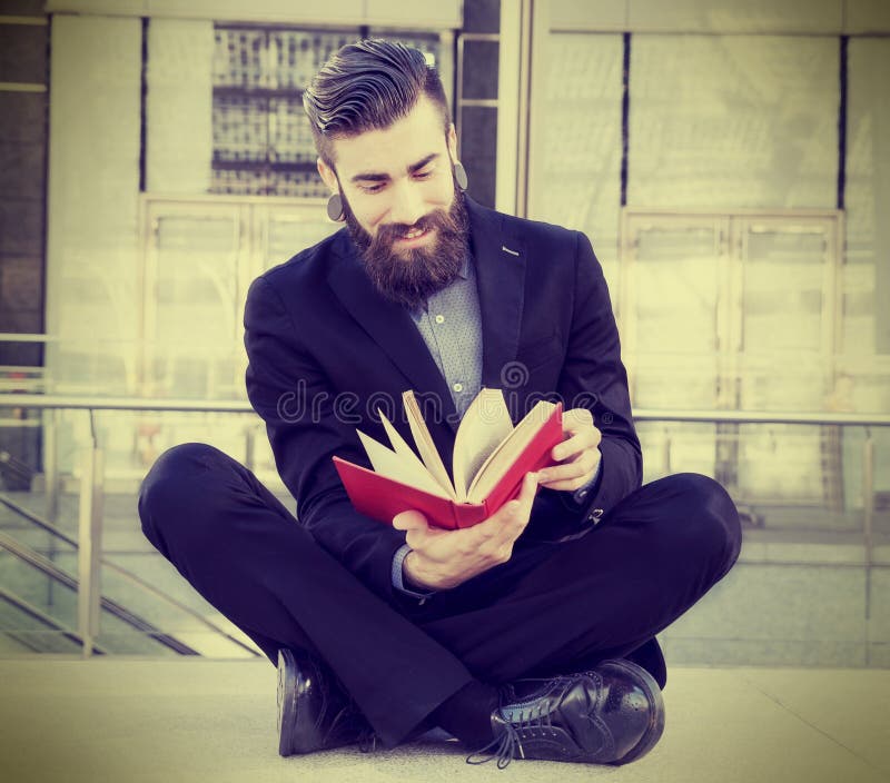 Young Hipster Reading a Book Sitting Outdoors Stock Photo - Image of ...