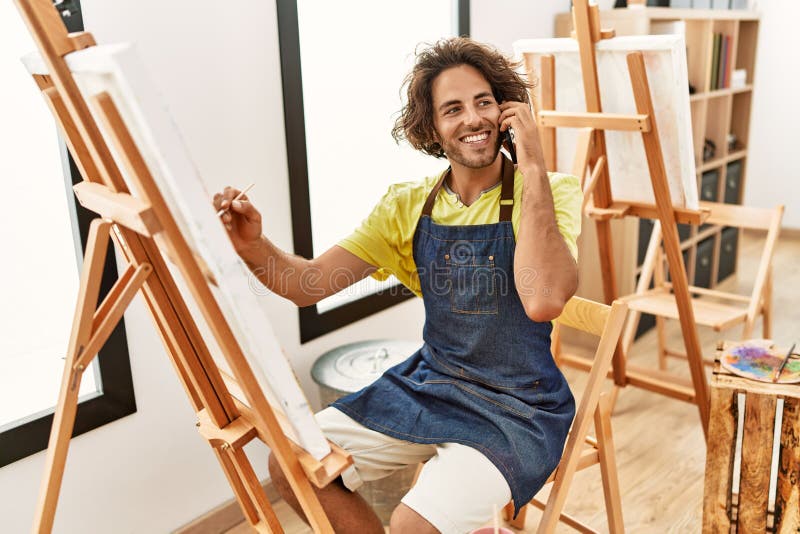Young Hispanic Artist Man Smiling Happy Drawing and Talking on the ...