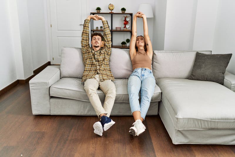 Young Hispanic Couple Relaxed Stretching Arms Sitting on the Sofa at ...