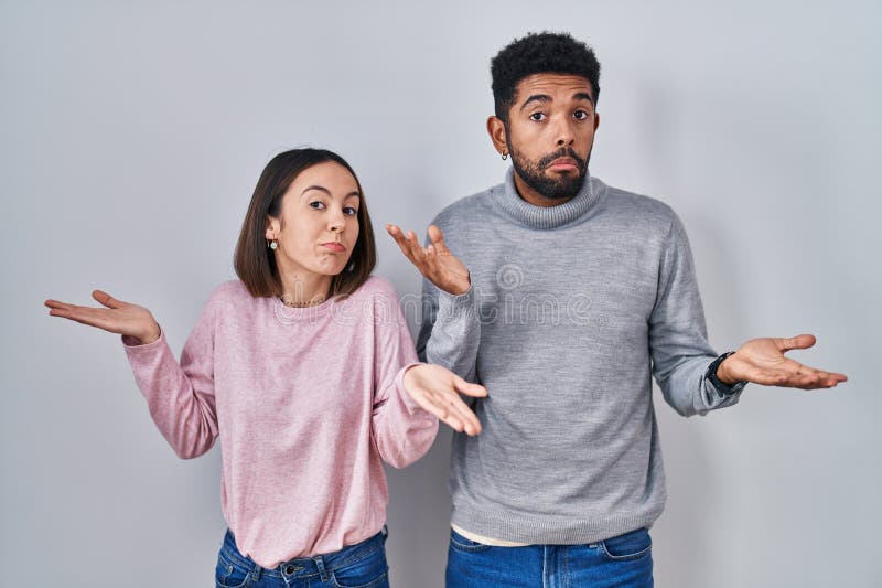 Young Hispanic Couple Standing Together Clueless and Confused ...