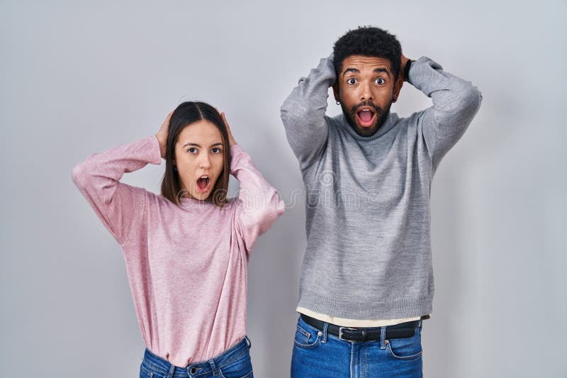 Young Hispanic Couple Standing Together Crazy and Scared with Hands on ...