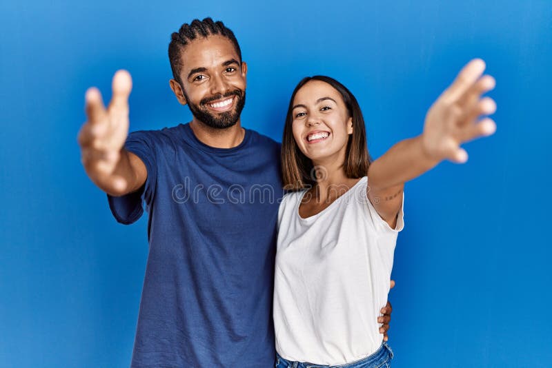 Young Hispanic Couple Standing Together Looking at the Camera Smiling ...