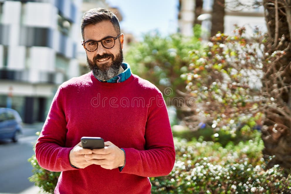 Young Hispanic Executive Man Smiling Happy Using Smartphone at the City ...