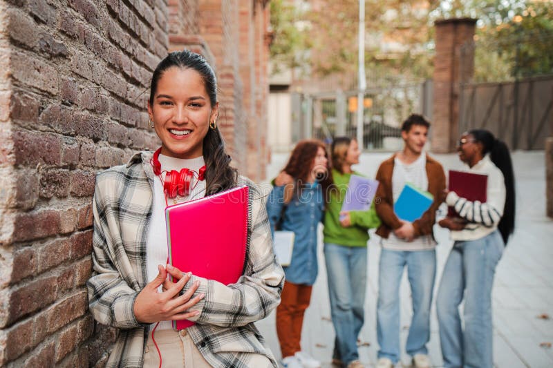 Young Hispanic Female Student Smiling at the Camera while Holding a Red ...