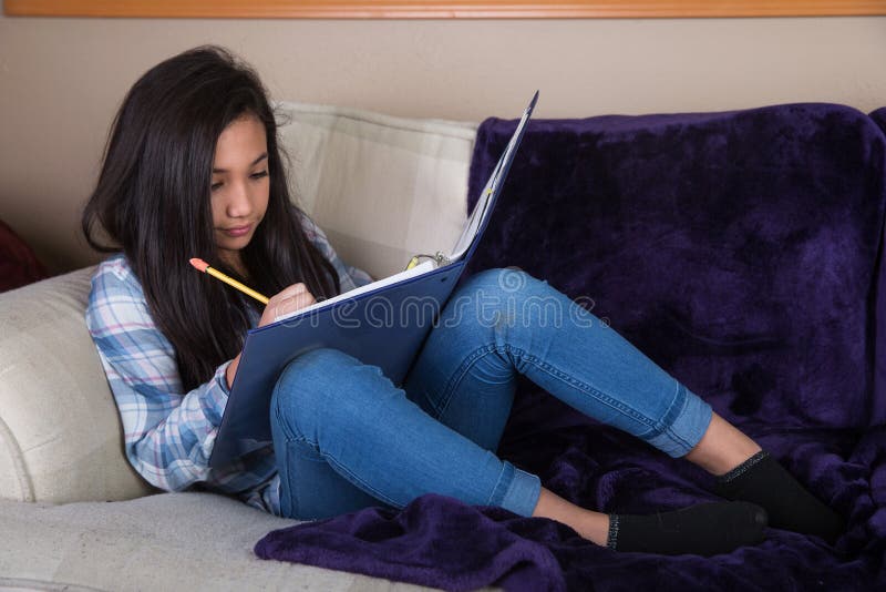 Young Hispanic Girl Doing Homework on the Couch Stock Image - Image of ...
