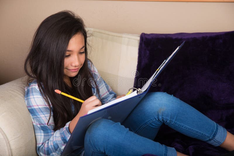 Young Hispanic Girl Doing Homework on the Couch Stock Image - Image of ...