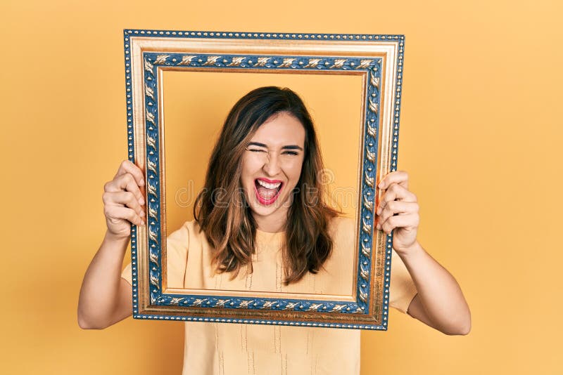Young Hispanic Girl Holding Empty Frame Winking Looking at the Camera ...