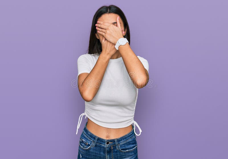 Young Hispanic Girl Wearing Casual White T Shirt Covering Eyes And