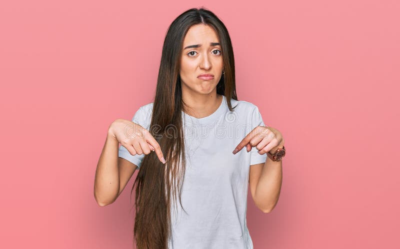 Young Hispanic Girl Wearing Casual White T Shirt Pointing Down Looking