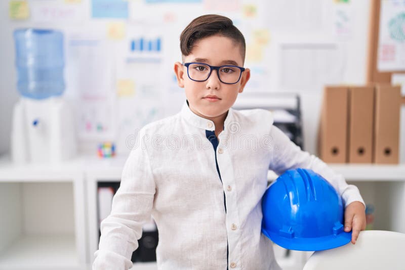 Young Hispanic Kid Holding Architect Hardhat at the Office Thinking ...