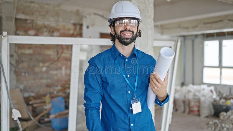 Young Hispanic Man Architect Smiling Confident Holding Blueprints at ...