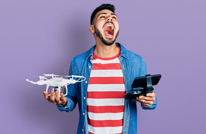 Young Hispanic Man with Beard Using Drone with Remote Control Angry and ...