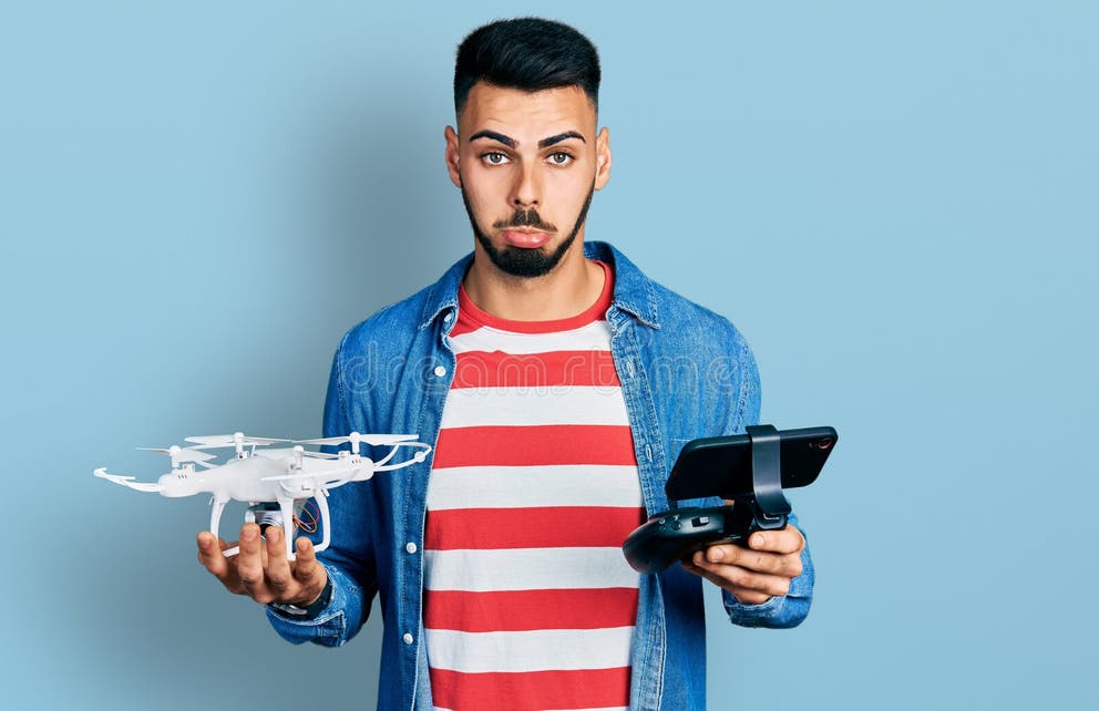 Young Hispanic Man with Beard Using Drone with Remote Control Depressed ...