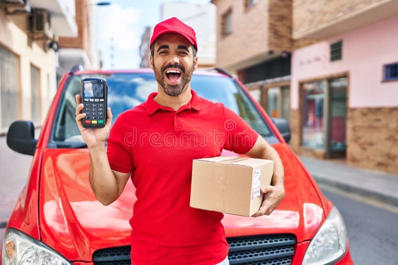 Young Hispanic Man With Beard Wearing Delivery Uniform And Cap Holding