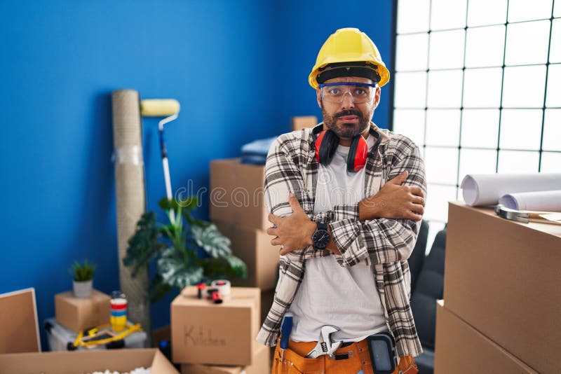Young Hispanic Man with Beard Working at Home Renovation Shaking and ...