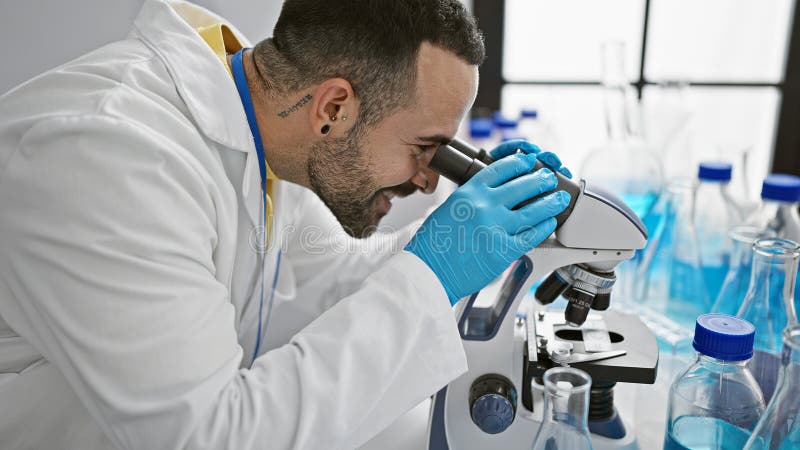 A Young Hispanic Man with a Beard Works Diligently in a Lab, Analyzing ...
