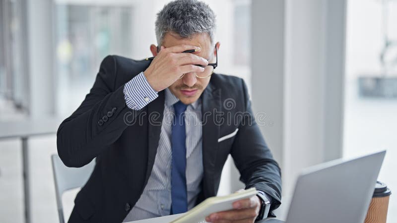 Young Hispanic Man Business Worker Using Laptop Writing Notes Stressed ...