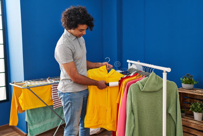 Young Hispanic Man Cleaning Clothes Using Pet Hair Roller at Laundry ...