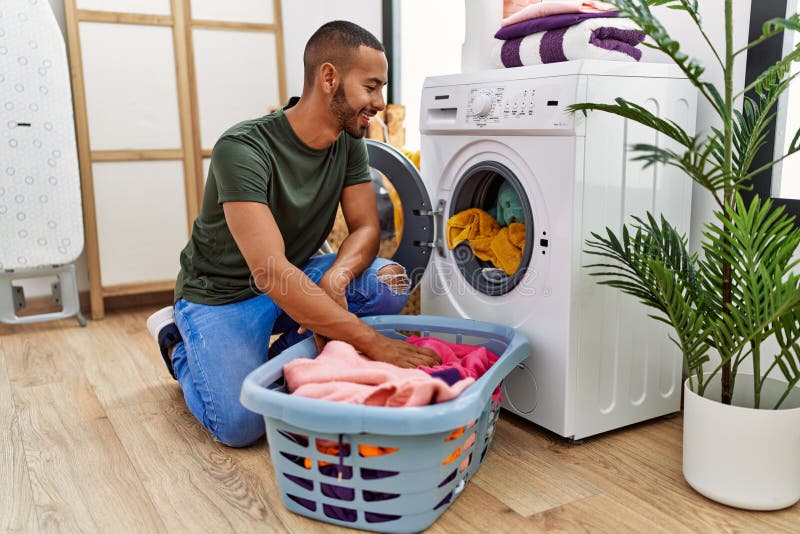 Young Hispanic Man Cleaning Clothes Using Washing Machine at Laundry ...