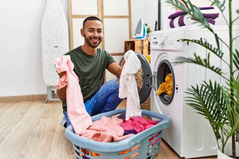Young Hispanic Man Cleaning Clothes Using Washing Machine at Laundry ...