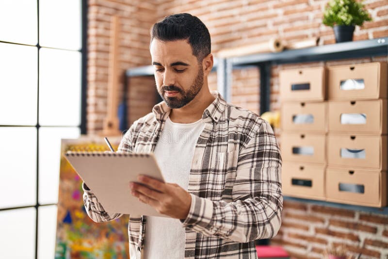 Young Hispanic Man Drawing on Notebook at Art Studio Stock Photo ...