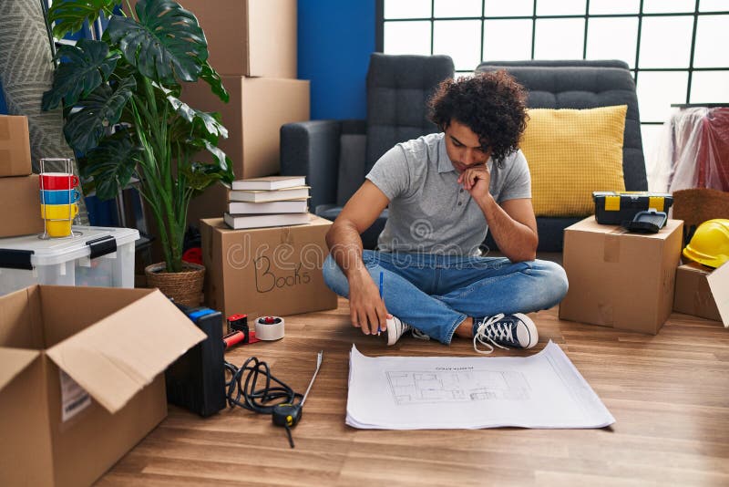 Young Hispanic Man Having Idea Writing on House Plan at New Home Stock ...