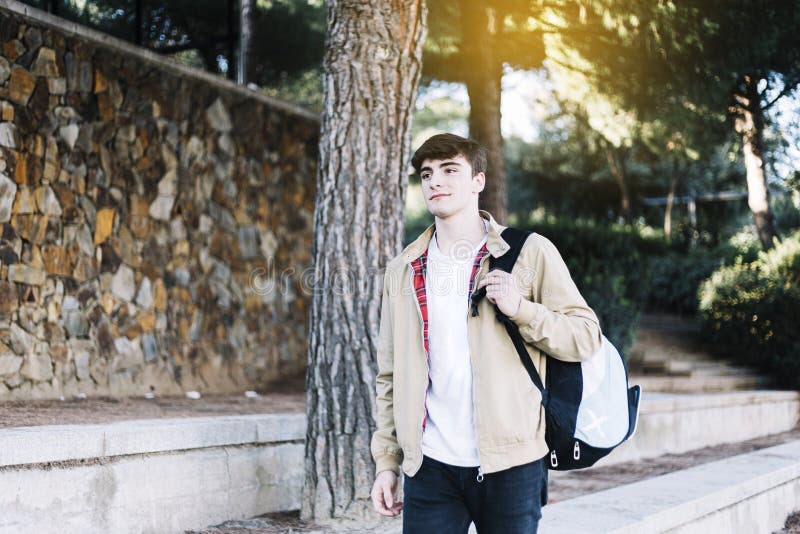 Young Hispanic Man Holding Backpack while Walking Outdoors Stock Photo ...