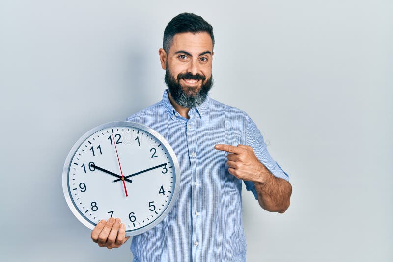 Young Hispanic Man Holding Big Clock Smiling Happy Pointing with Hand ...