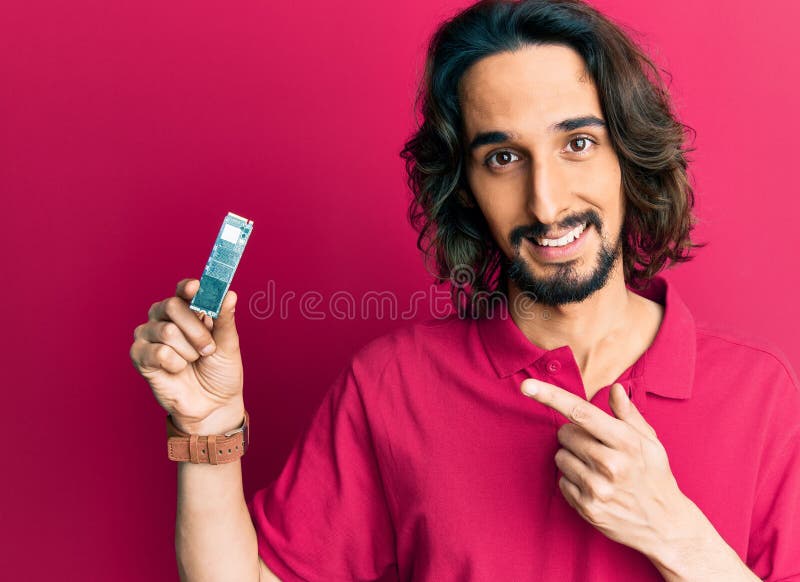 Young Hispanic Man Holding Computer Memory Smiling Happy Pointing with ...